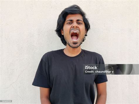 Young Clean Shaved South Indian Wearing Black Tshirt With Mouth Open Or