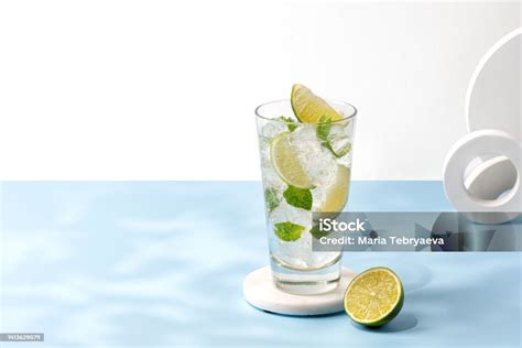 모히토 연단에서 차가운 여름 음료를 마신다 석회와 함께 차가운 강장제 유리 파란색 배경에 얼음과 박하가있는 레모네이드 공간 복사 모히토에 대한 스톡 사진 및 기타 이미지