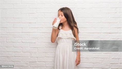 흰색 벽돌 벽 스마트 얼굴 심각한 생각에 자신감이 식으로 우유 한 잔을 마시는 동안 젊은 히스패닉 아이 감정에 대한 스톡 사진 및 기타 이미지 Istock