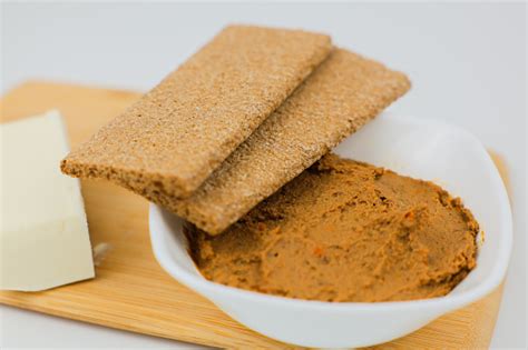 나무 판자를 클로즈업하면 간 파테가 있는 흰색 접시가 있고 그 위에는 빵 조각이 놓여 있고 그 옆에는 흰색 배경에 버터 조각이 있습니다 건강한 음식 건강한 간식의 컨셉입니다