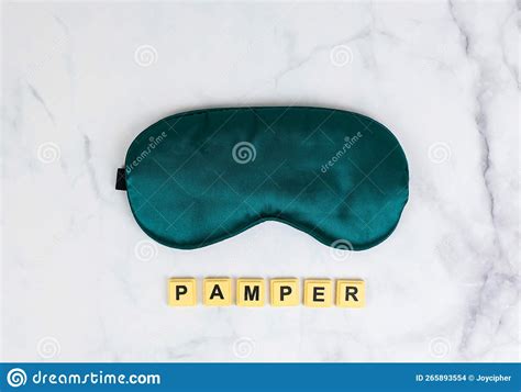 Close Up Of Soft Clean Green Satin Sleeping Mask On White Background With The Word Pamper Self