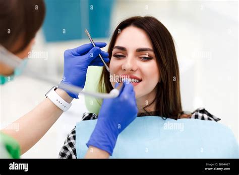 Woman At The Dentistry Dentist Treats Teeth To His Pretty Patient