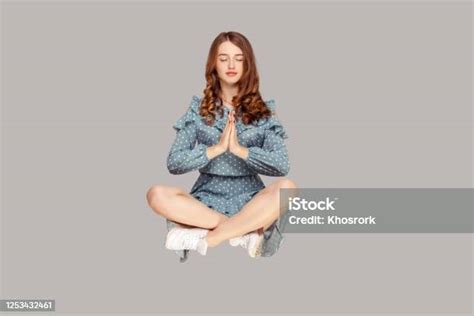 공중에 떠있는 평화로운 차분한 편안한 소녀 러플 드레스는 기도 제스처로 부풀어 눈을 감고 명상 비어 있음에 대한 스톡 사진 및