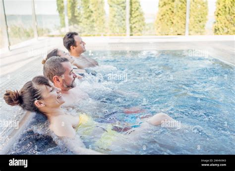 Two Married Couples Chat And Take An Outdoor Pool Friends Laugh And Relax In The Swirling Water