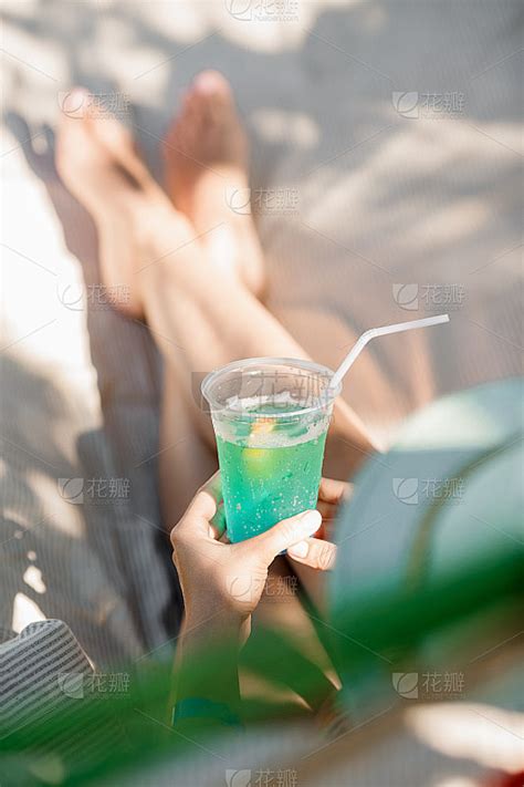 吊床上拿着鸡尾酒的女人
