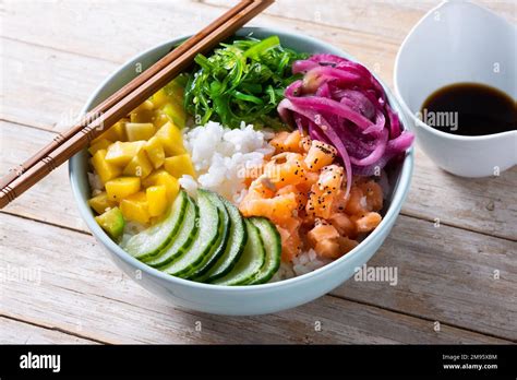 Un Bol De Poke Avec Du Riz Du Saumon Du Concombre De La Mangue De L