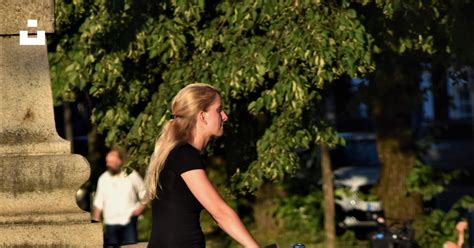 검은색 탱크탑과 파란색 데님 반바지를 입은 여자가 낮에 녹색 자전거 옆에 서 있다 사진 Unsplash의 무료 노이하우젠 님펜부르크 이미지