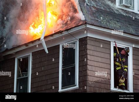 Firefighters Work To Extinguish A Multiple Alarm House Fire In