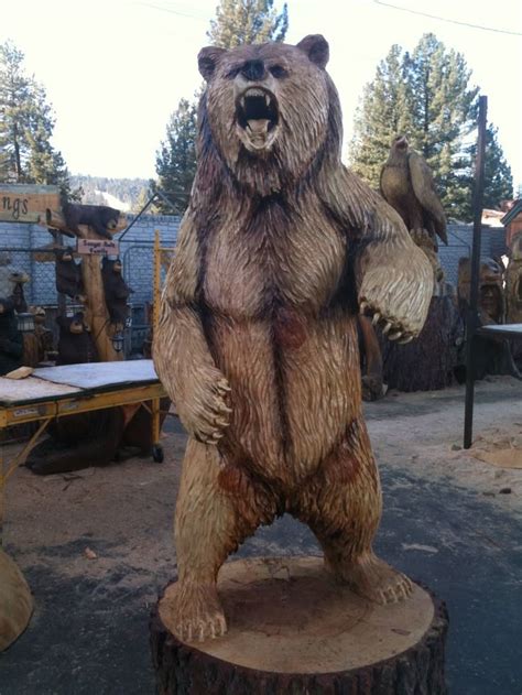 A Statue Of A Bear Standing On Top Of A Tree Stump