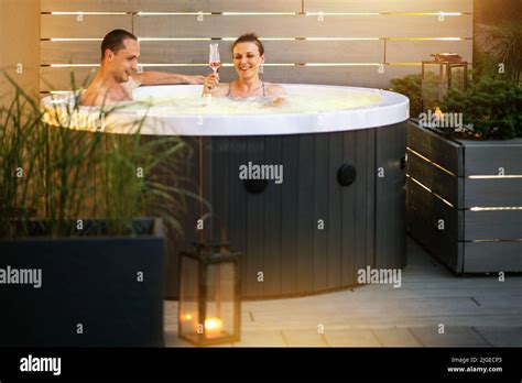 Caucasian Couple Having Fun And Lazy Time Inside A Garden Hot Tub