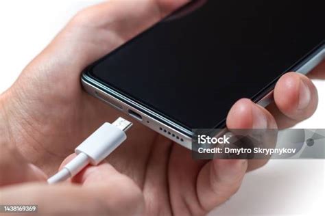 Usb 케이블과 전원 공급 장치를 통해 스마트폰 충전 Usb 충전 케이블이 걸려있는 검은 색 스마트 폰 공란에 대한 스톡 사진