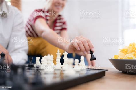 집 거실에는 노부부가 앉아 휴식을 취한다 옆에 응원하는 딸과 함께 체스 판과 함께 체스를 시작합니다 가정 생활에 대한 스톡 사진