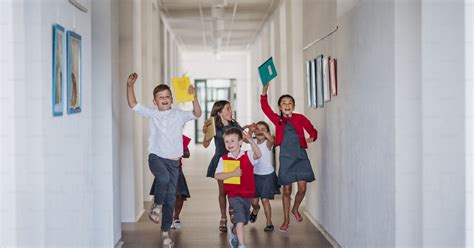 복도에서 쾌활한 작은 학교 아이들 달리기와 점프 학교 개념으로 돌아갑니다 사진 Unsplash의 복도 이미지