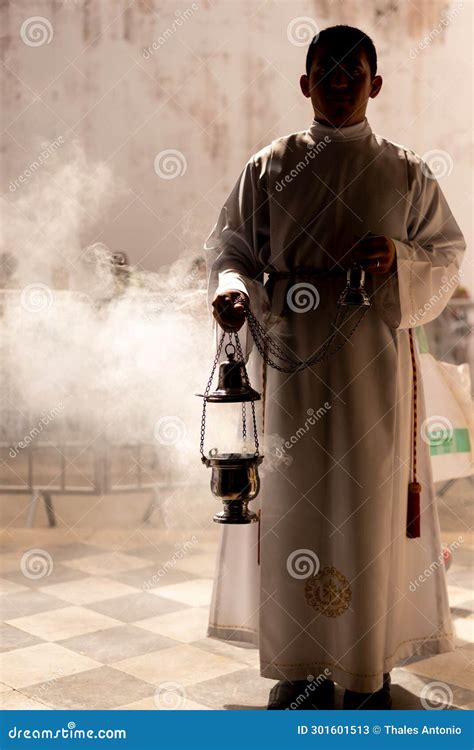 Catholic Seminarian Waving The Candlestick During Mass At The Church Of