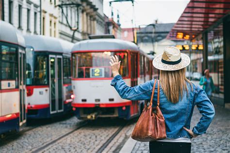 여자는 입고 청바지 자 켓와 밀 짚 모자 그녀는 도시에서 전차를 떠나에 물결치는 떠나는 사람에 게 Goodbay를 말한다 손 흔들기에 대한 스톡 사진 및 기타 이미지