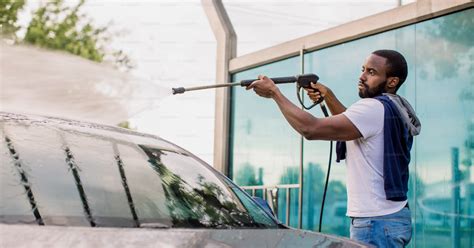 캐주얼 복장을 한 잘 생긴 아프리카 청년은 야외 셀프 세척 서비스에서 물 고압 호스로 빨간 차를 수동으로 씻습니다 세차 개념 사진 Unsplash의 세차장 이미지