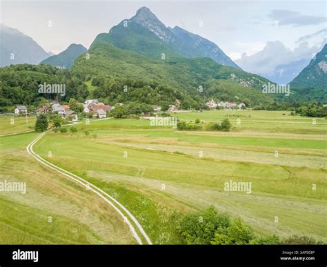 Aerial View A Dirt Road Surrounded By Green Grass In Slovenia Stock