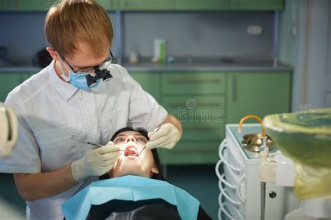 The Dentist Begins To Examine The Oral Cavity Of A Beautiful Girl Stock