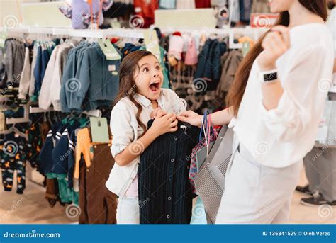 Mother And Daughter In Shopping Mall Girl Is Excited About New Sweater