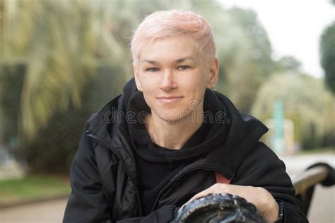 Positive Woman With Short Hair Smiling Sitting And Looking At Camera