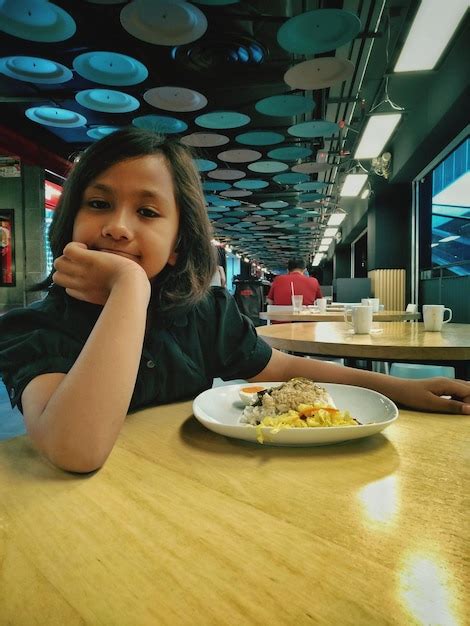 Premium Photo Portrait Of Girl Eating Food At Restaurant