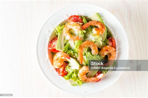 토마토 루 콜라 아보카도 새우 치킨 유 방 Arugula 크래커와 향신료로 만든 신선한 새우 샐러드 나무 배경에 흰색 투명 한