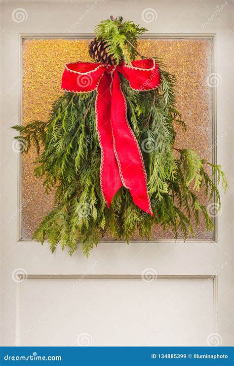 Vintage Style Red Bow Tied To Evergreen Christmas Wreath Stock Image