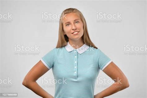 금발 머리 검은 눈 건강 한 피부와 만족된 예쁜 여자 블루 줄무늬 T셔츠 흰색 벽에 포즈를 취하는 동안 웃 고 주머니에 손을 잡고 입고 사람과 생활 갈색 눈에 대한 스톡