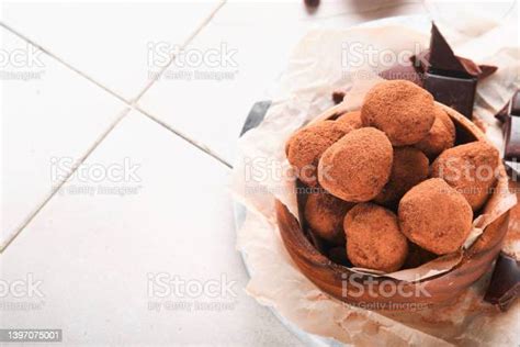 오래된 금이 간 타일 테이블 배경에 나무 접시에 코코아 파우더가 들어간 초콜릿 트뤼플 맛있는 달콤한 초콜릿 트뤼플 사탕 발렌타인