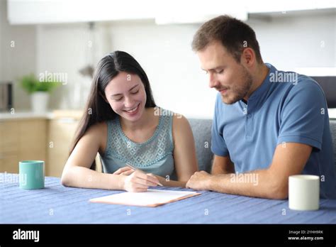 Happy Interracial Roommates Or Couple Signing Contract In The Kitchen