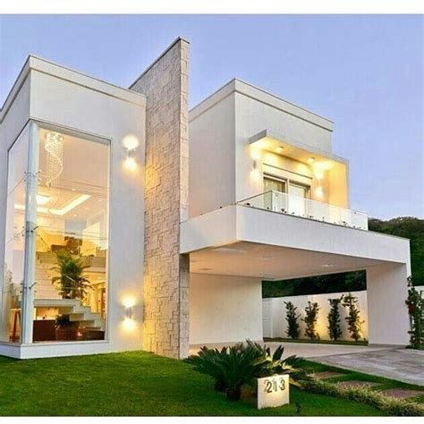 A Large White House Sitting On Top Of A Lush Green Field