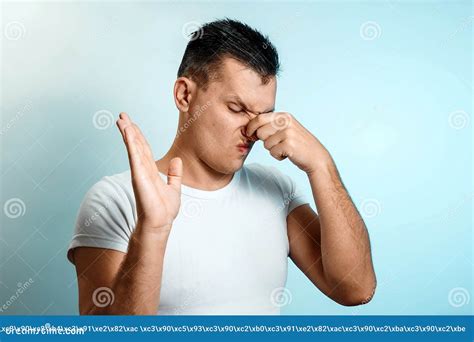 Close Up Portrait Of A Man Closes His Nose With His Hands On A Light