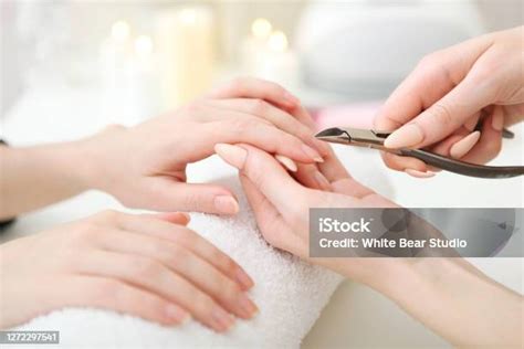 네일 살롱에서 네일 살롱에서 네일 파일과 미용사에 의해 매니큐어를 받고 여자의 클로즈업 샷 여자는 손톱의 매니큐어를 가져옵니다 미용사는 클라이언트에 못을 넣습니다 2명에