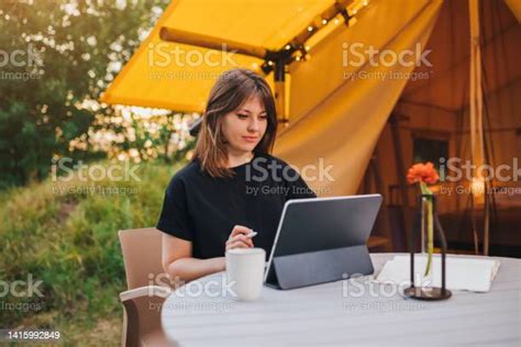 화창한 날에 아늑한 글램핑 텐트에서 노트북을 사용하는 해피 우먼 프리랜서 야외 여름 휴가 및 휴가를위한 고급 캠핑 텐트 라이프스타일 개념 30 34세에 대한 스톡 사진 및