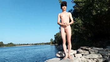 Naked Asian Boy Doing Yoga Outdoors Above Water While Passing Men In