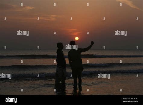 People Take A Selfie Photo While The Last Sunset Of 2021 Hangs Over The