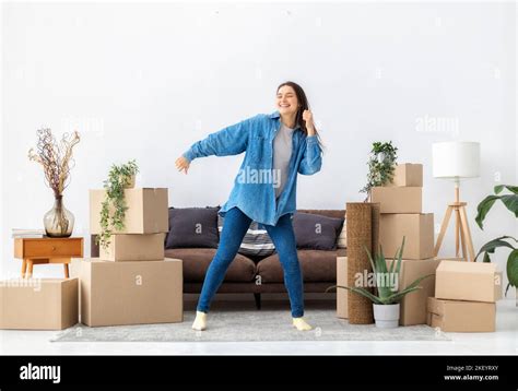 Young Happy Woman Dances With Happiness After Moving Into Her New House