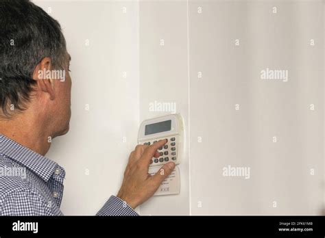 Man Operating On An Alarm Keypad On A White Wall Stock Photo Alamy