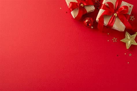 축제 시즌 카운트다운 진홍색 배경에 소박한 선물 상자 강렬한 빨간색과 금색 장식품 별 겨우살이 열매 색종이 조각의 오버헤드 샷 명절 메시지에 적합 12월에 대한 스톡 사진