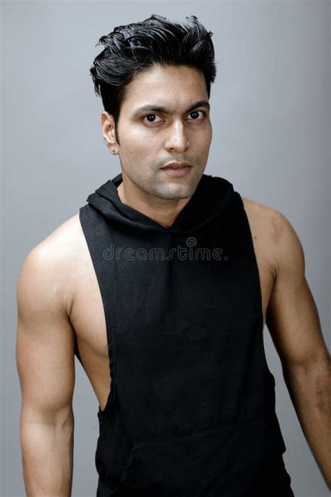 Indian Young Male Model In Casual Wear Wearing Black Tshirt And Blue
