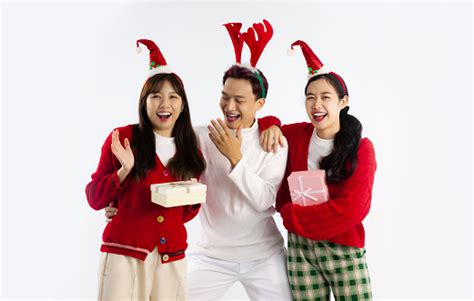 빨간색과 흰색 스웨터를 입은 젊은 아시아 남녀가 흰색 백라운드에 선물 상자를 들고 있다 즐거운 성탄절 아시아인에 대한 스톡 사진