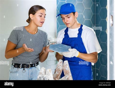 Builder Discussing Tiles With Female Owner Of Apartment Being Renovated Stock Photo Alamy