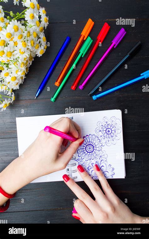 Female Drawing Flower Shapes In A Notebook Stock Photo Alamy