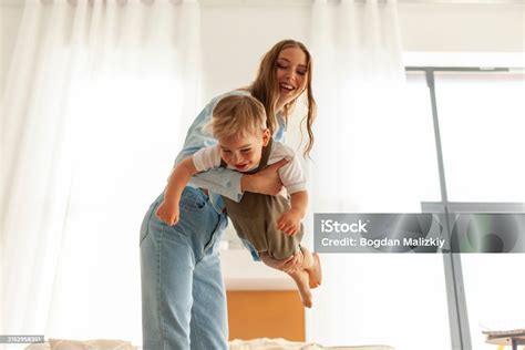젊은 어머니는 집에서 어린 아들과 춤을 추고 손을 잡고 여자는 방에서 아이와 놀고 있습니다 날기에 대한 스톡 사진 및 기타 이미지 Istock