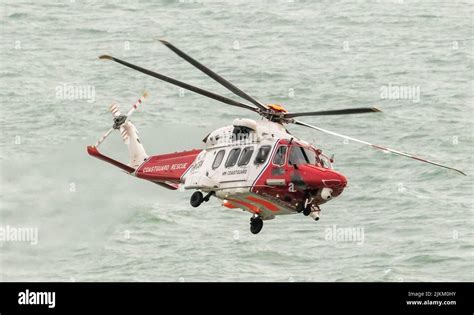 Coastguard Helicopter Hovering Near Lighthouse Below The Cliffs At