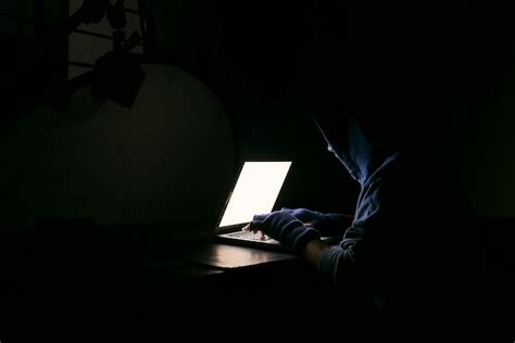 Premium Photo Hacker Hand Stealing Data From Laptop Top Down