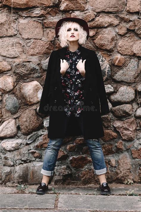 Beautiful Cute Blonde Girl With Curly Hair In A Hat And Black Coat Near