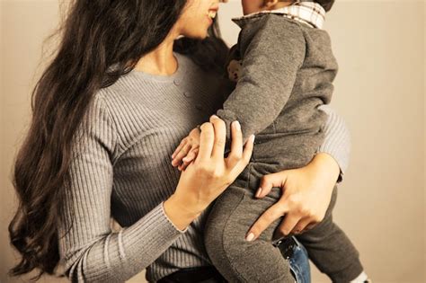 Madre Joven Que Celebra A Su Hijo En Sus Brazos Foto Premium