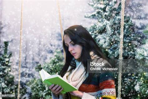 Wanita Muda Membaca Buku Sambil Duduk Di Ayunan Dengan Selimut Di Pagi