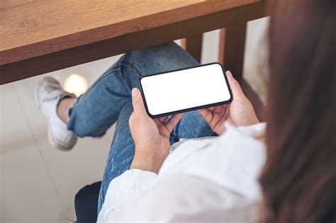 앉아있는 동안 수평으로 빈 데스크톱 화면으로 검은 휴대 전화를 들고 여자의 상위 뷰 이랑 이미지 공란에 대한 스톡 사진 및 기타